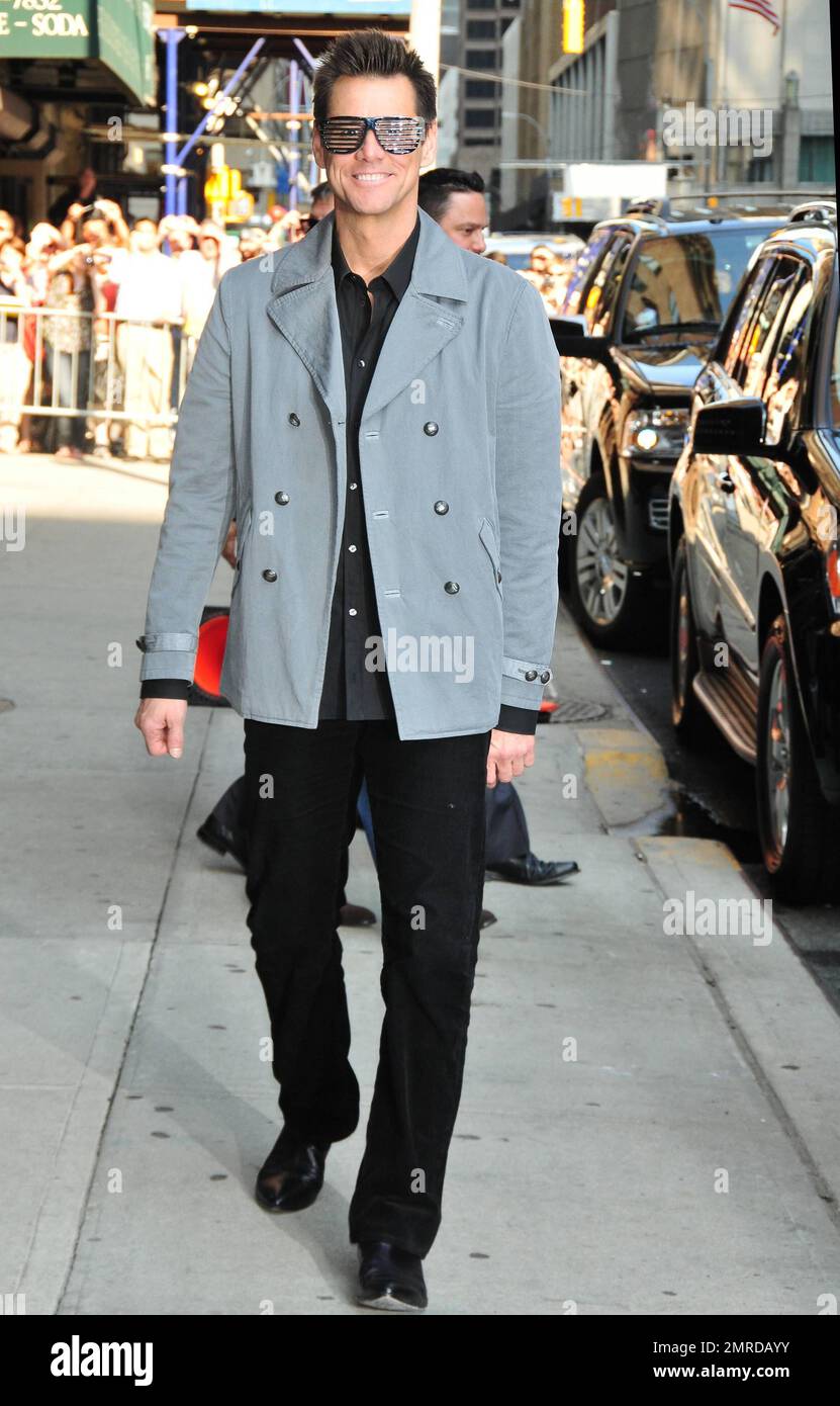 Jim Carrey wears some funky slatted sunglasses as he poses for photos ...