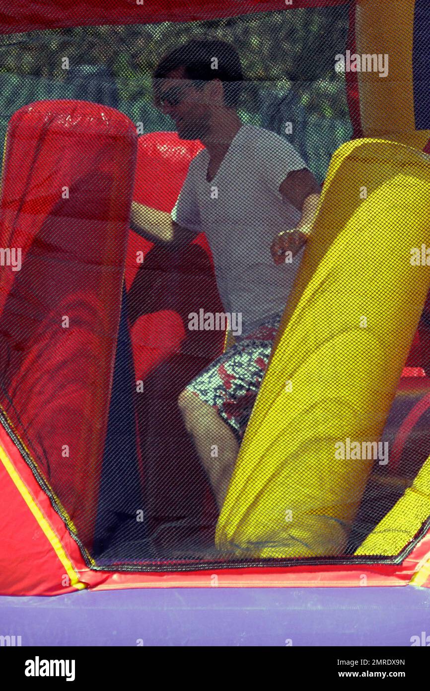 Tobey Maguire plays in the bounce house on the beach with daughter Ruby ...