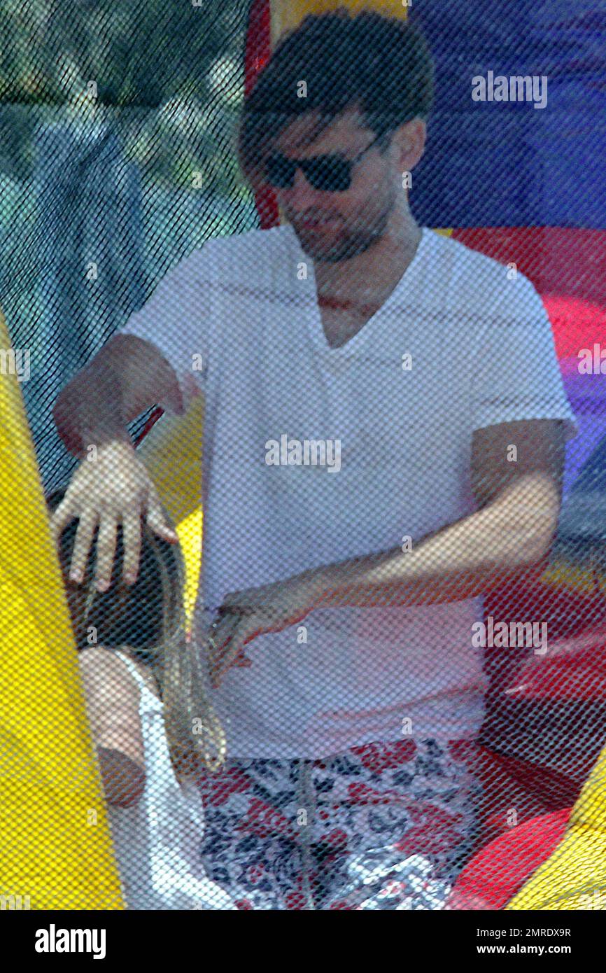 Tobey Maguire plays in the bounce house on the beach with daughter Ruby ...