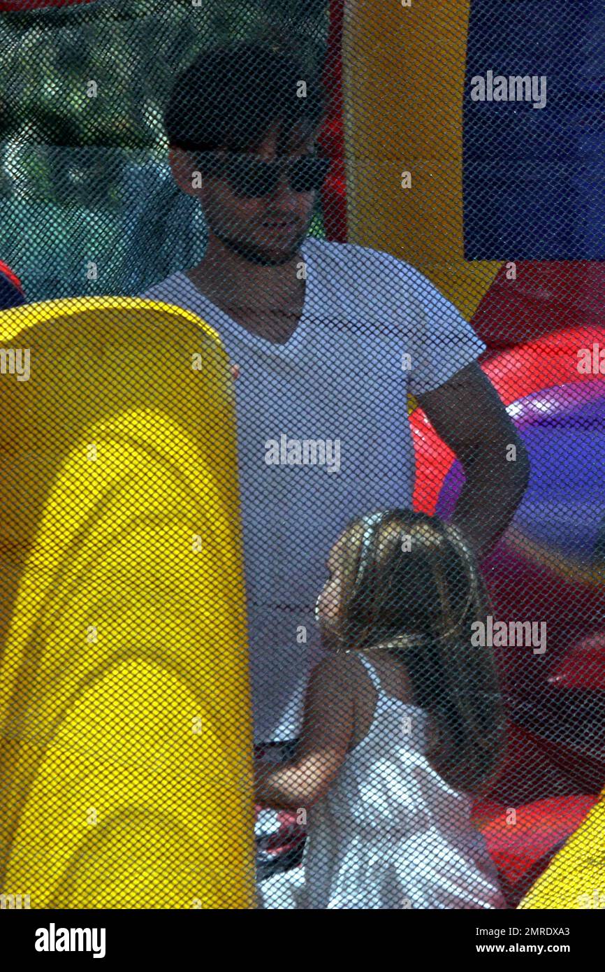 Tobey Maguire plays in the bounce house on the beach with daughter Ruby ...