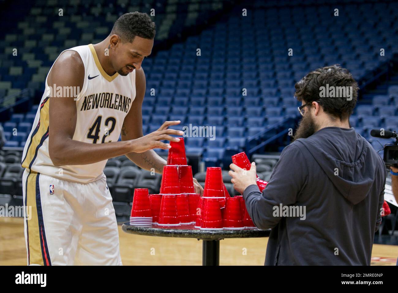 Pelicans center Alexis Ajinca plays a cup stacking contest with Chris ...