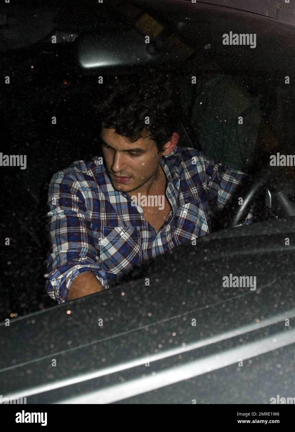 Musician John Mayer signs a guitar for a fan as he leaves the Hotel ...