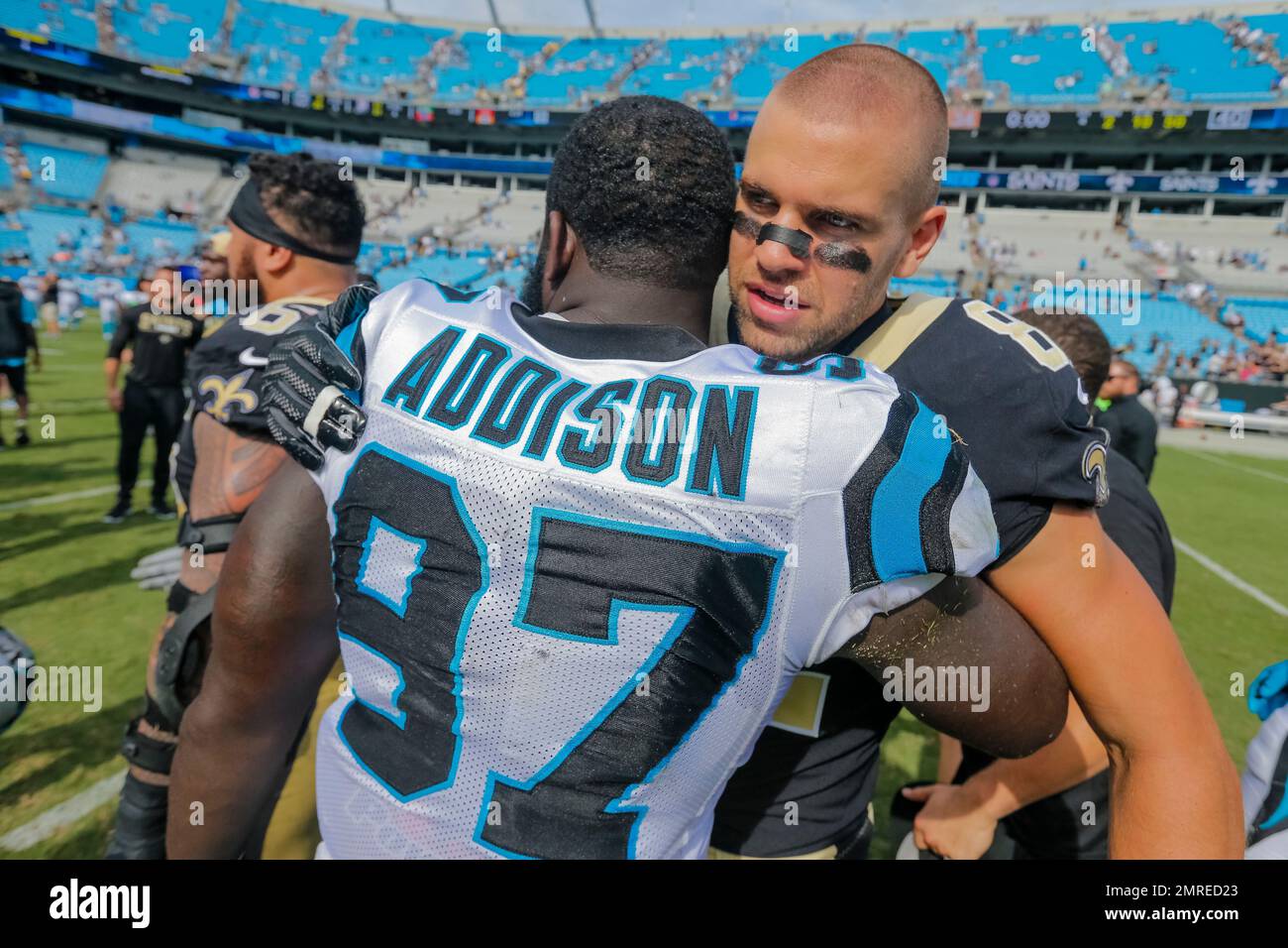 Carolina Panthers' Mario Addison (97) hugs New Orleans Saints' Coby ...