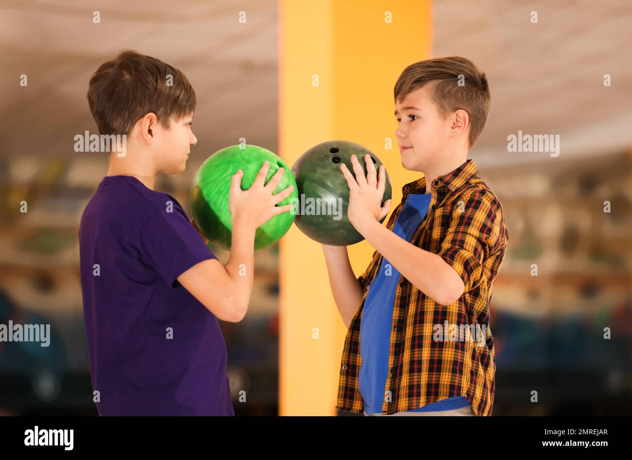 Happy boys with balls in bowling club Stock Photo - Alamy