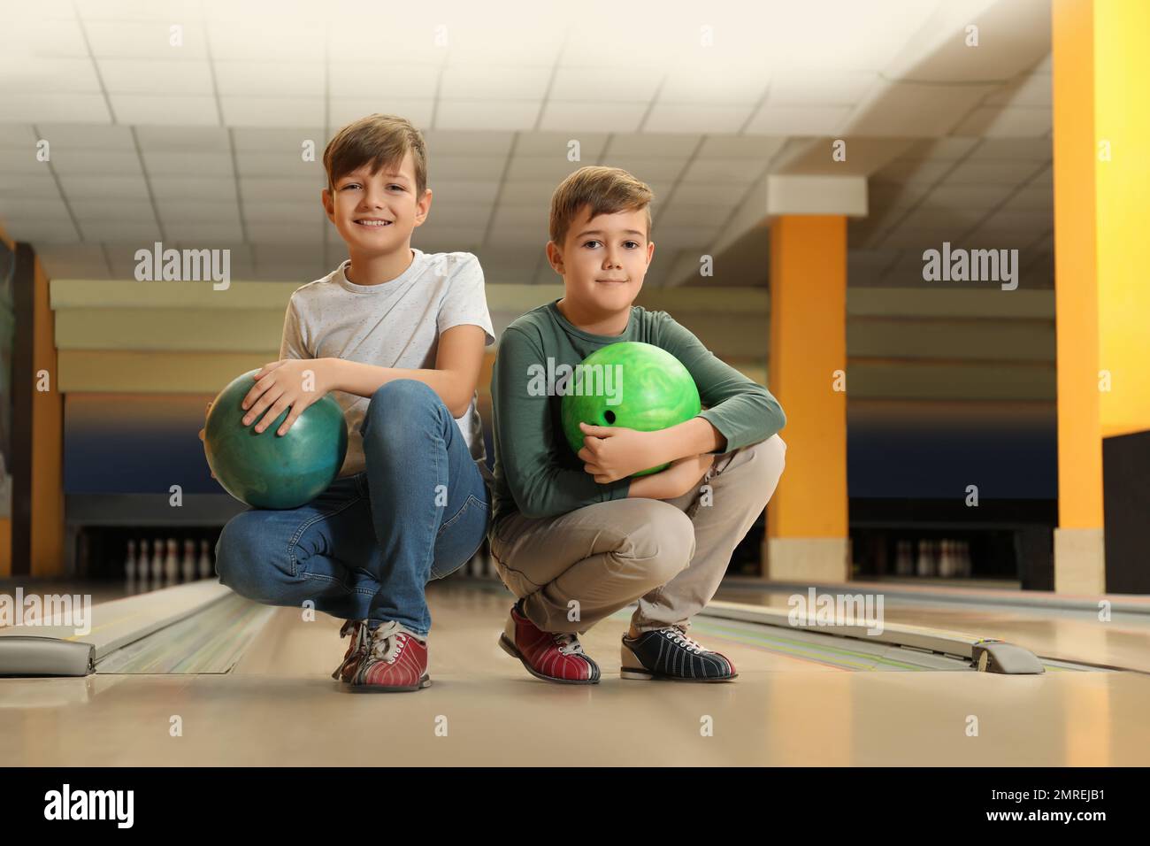 Happy boys with balls in bowling club Stock Photo - Alamy