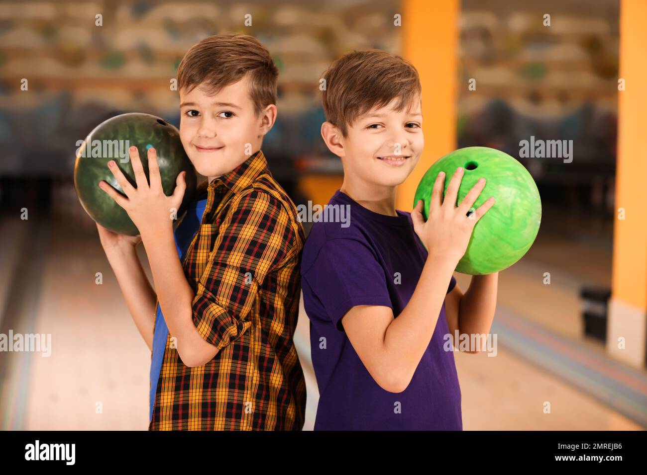 Happy boys with balls in bowling club Stock Photo - Alamy