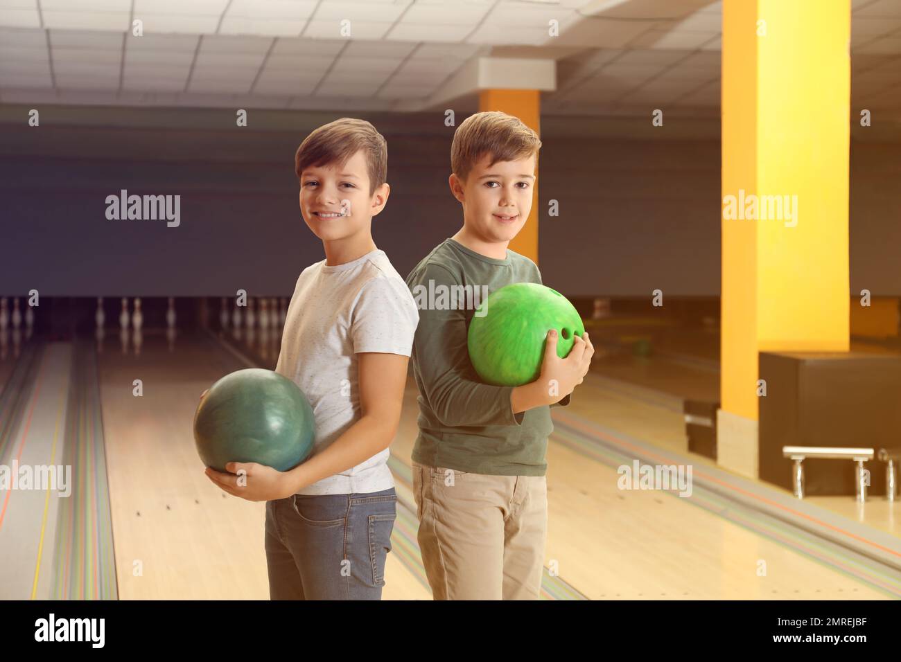 Happy boys with balls in bowling club Stock Photo - Alamy