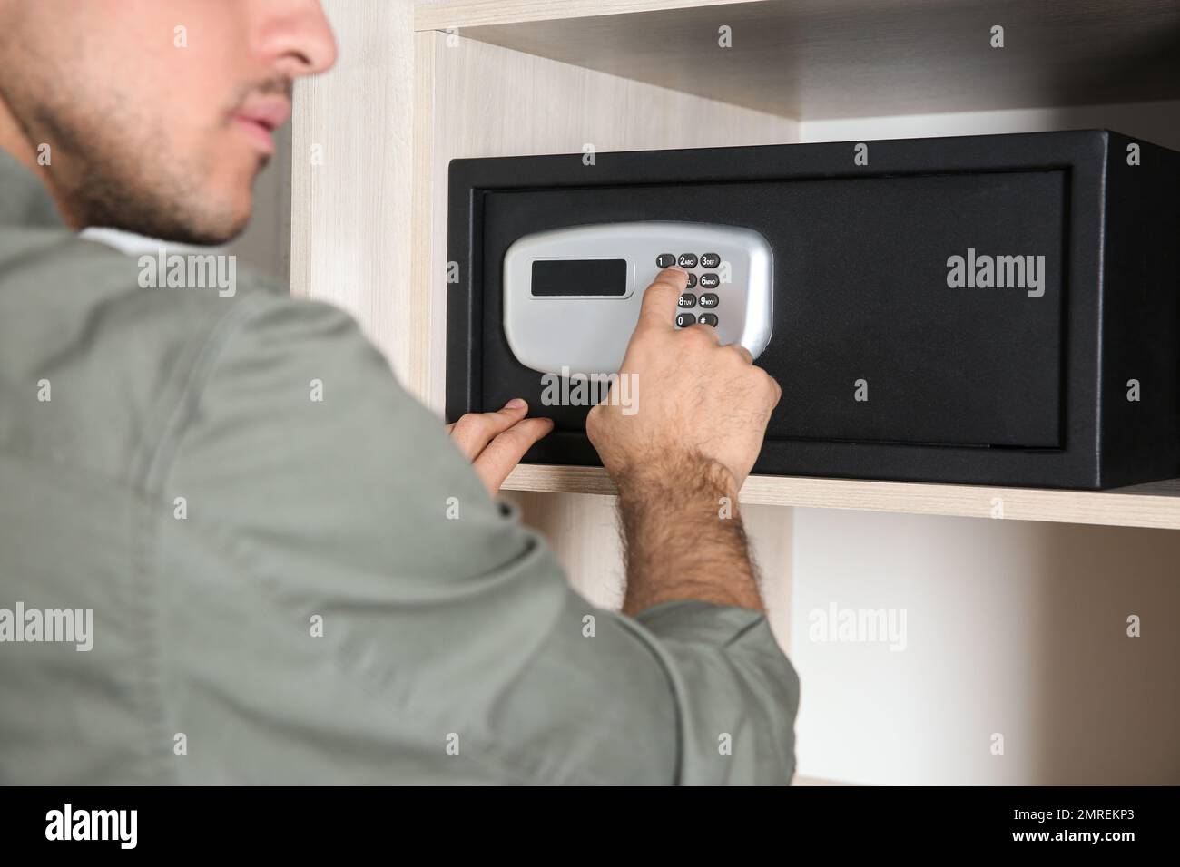 Man opening black steel safe with electronic lock at hotel, closeup ...