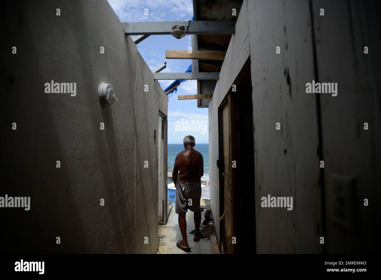 La Perla resident Ramon Marrero, 76, walks through his battered ...