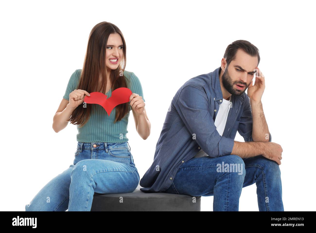 Woman tearing paper heart near her boyfriend on white background ...
