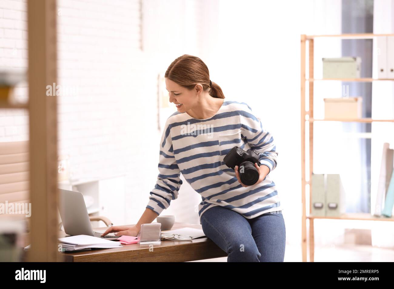 Young journalist working with laptop in light office Stock Photo - Alamy
