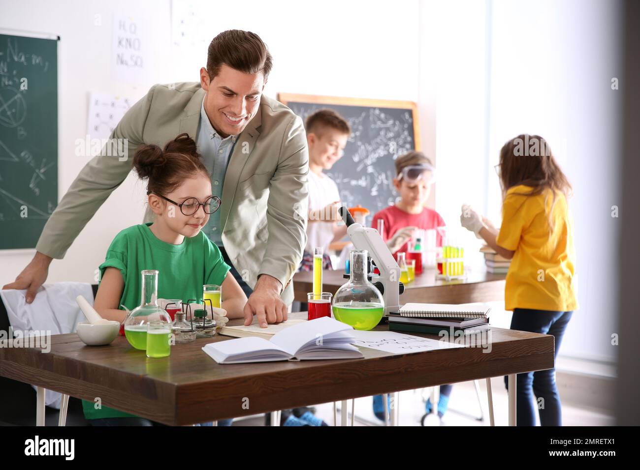 Teacher with pupils at chemistry lesson in classroom Stock Photo - Alamy