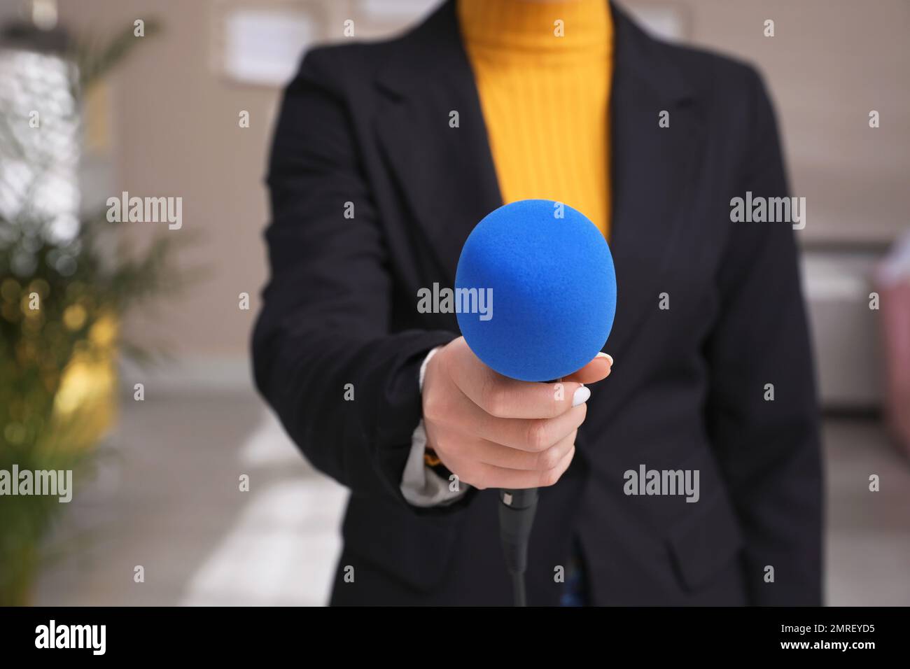 Professional journalist with modern microphone in room, closeup Stock ...