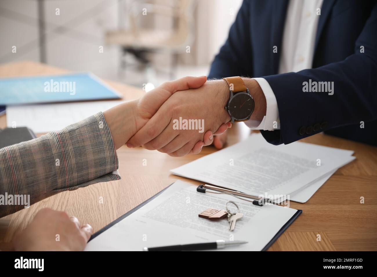 Real estate agent shaking hands with client in office, closeup Stock ...