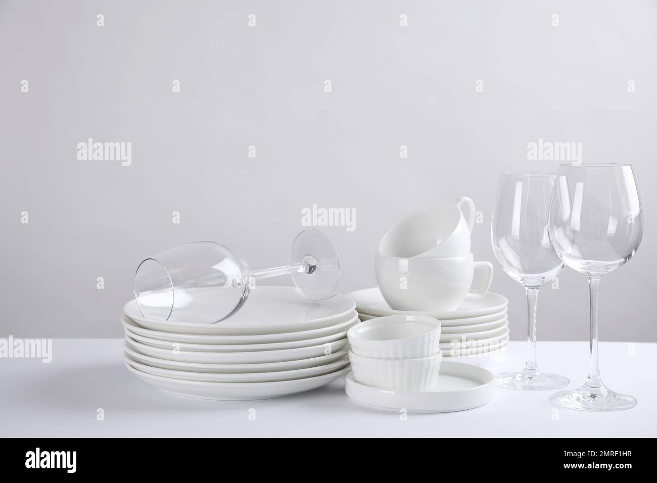 Set of clean dishes on white table Stock Photo - Alamy