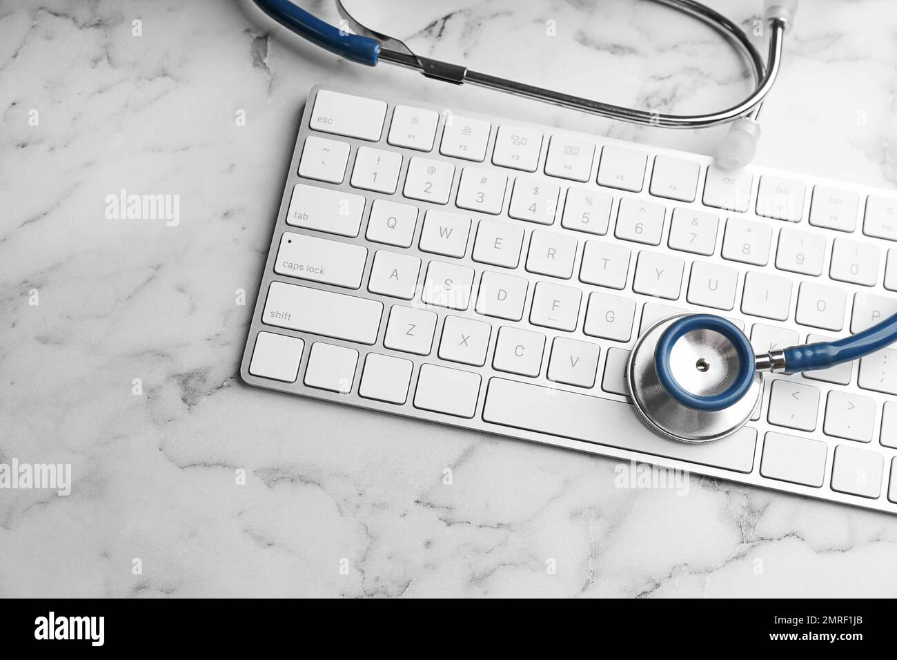 Keyboard and stethoscope on white marble table, flat lay. Concept of ...