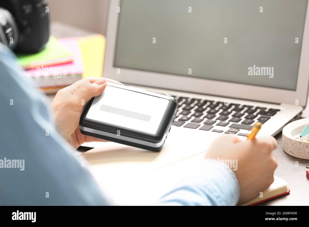 Journalist with voice recorder working at table in office, closeup ...