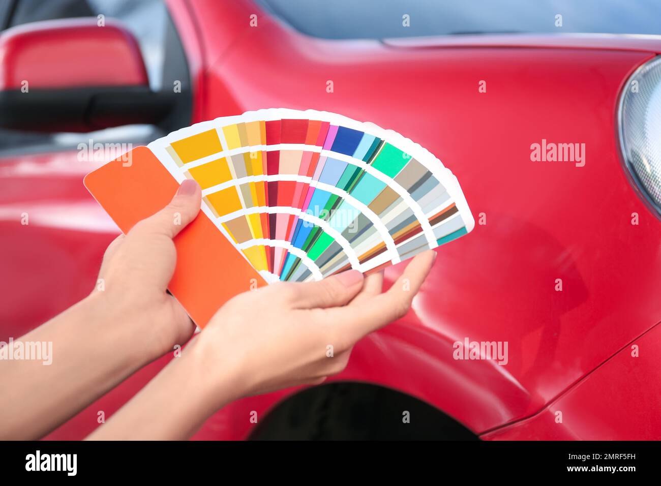 Woman with palette samples choosing color for painting car, closeup ...