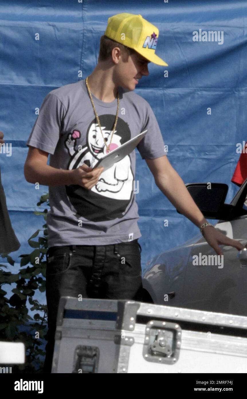 Teen pop superstar Justin Bieber carries an iPad as he arrives on the ...