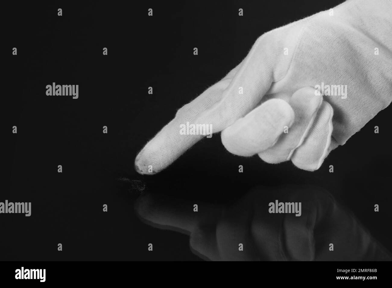Person in white glove checking cleanliness of black background, closeup ...