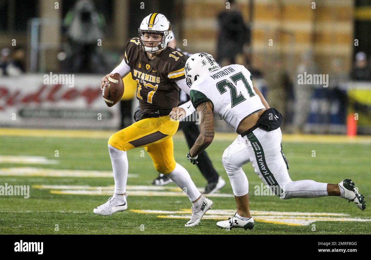 Wyoming quarterback Josh Allen (17) avoids a tackle from Hawaii ...