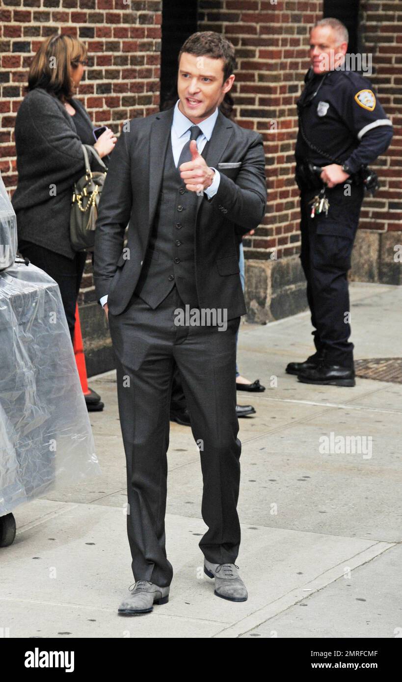 Justin Timberlake waves and flashes a thumbs up as he poses for photos ...