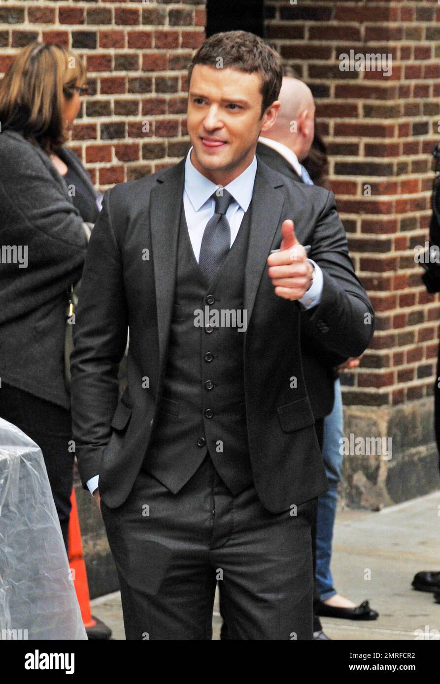 Justin Timberlake waves and flashes a thumbs up as he poses for photos ...