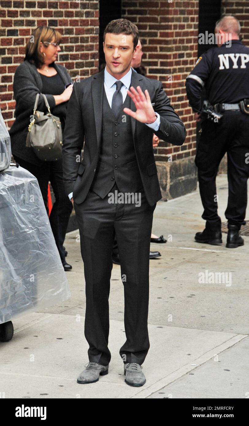 Justin Timberlake waves and flashes a thumbs up as he poses for photos ...