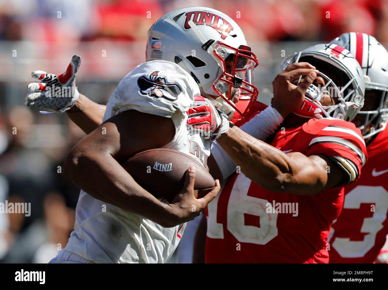 UNLV quarterback Armani Rogers, left, stiff arms Ohio State linebacker ...