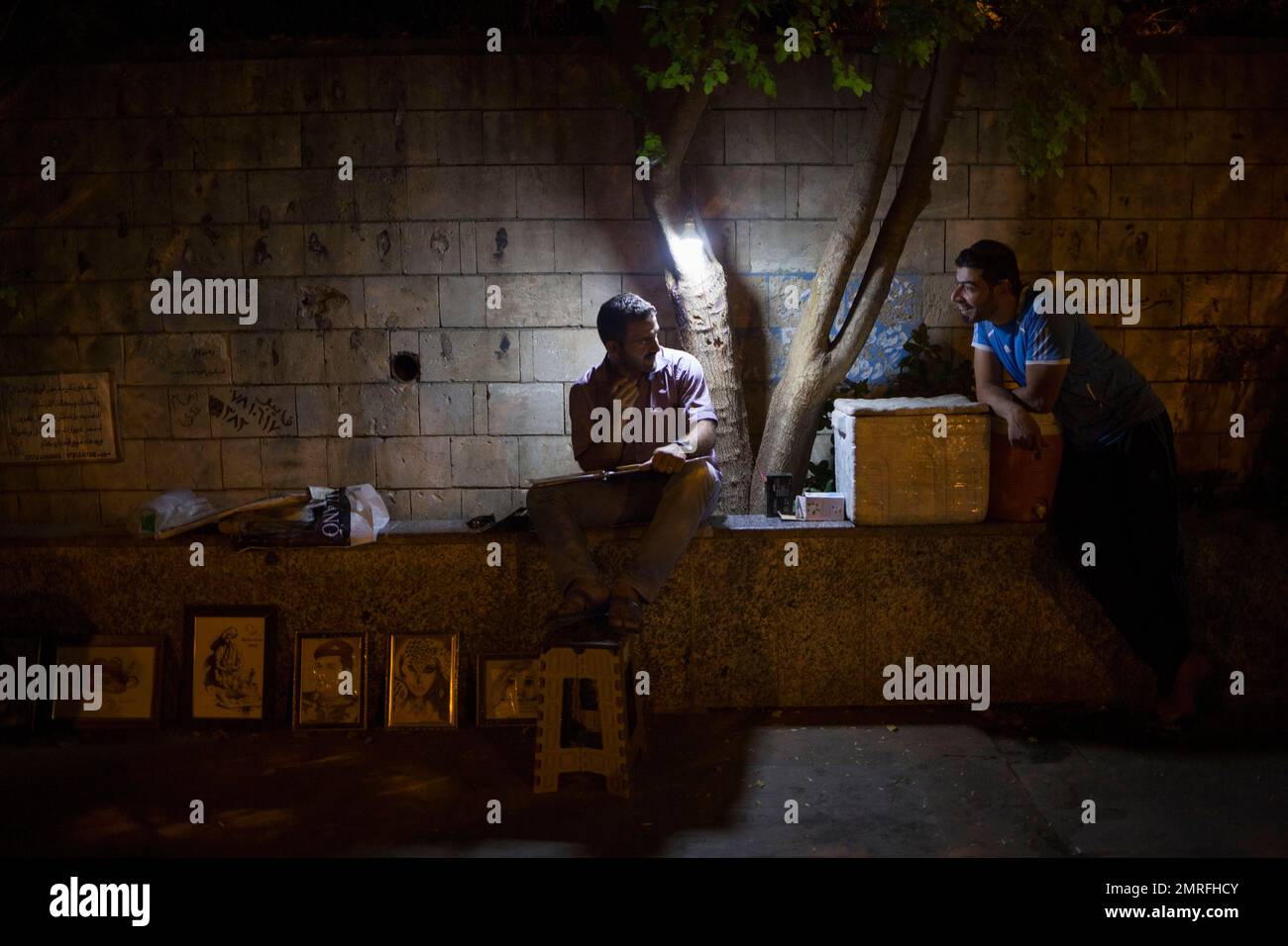 An artist and salesman talk in downtown Irbil, Saturday, Sept. 23, 2017. (AP Photo/Bram Janssen ...