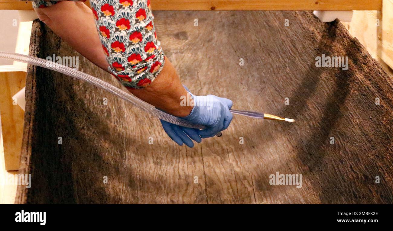 Jo Miles-Seely, carefully vacuums the fine dust from the cracks and ...