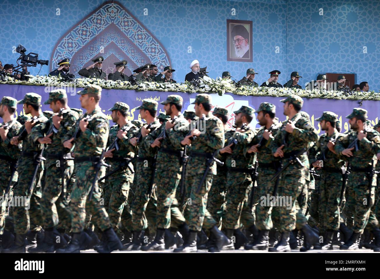 Iran's President Hassan Rouhani, top center, reviews army troops ...
