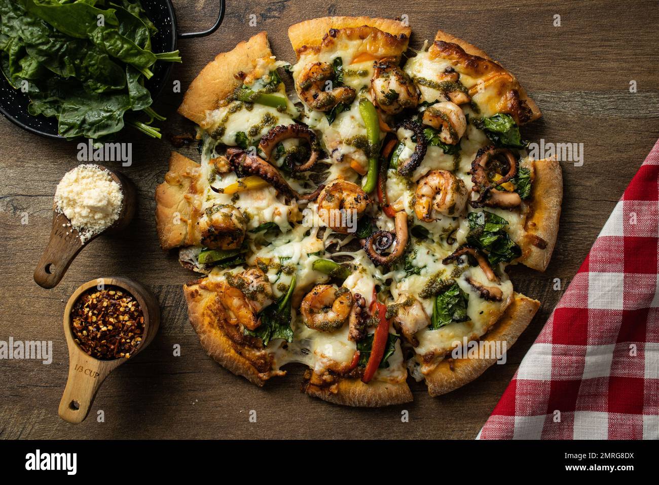 A top view of a pizza surrounded by ingredients on a rustic background ...