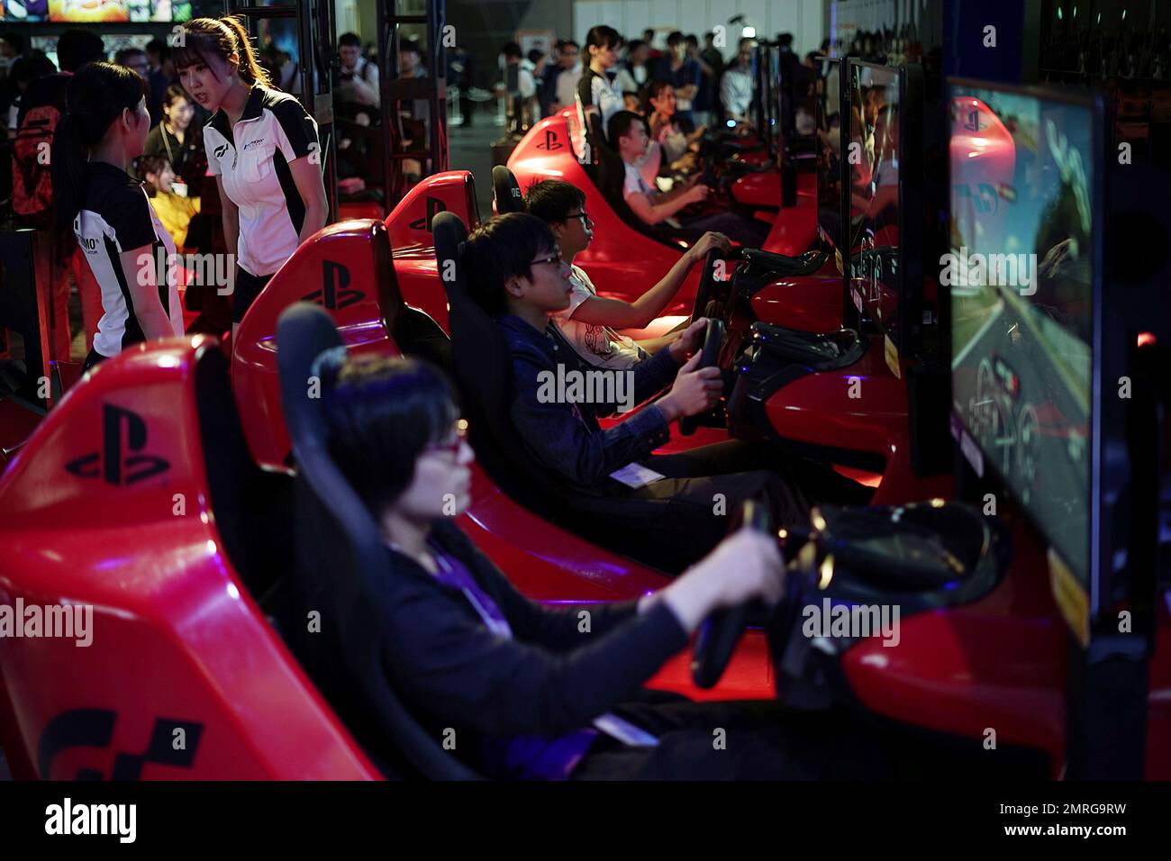 Visitors try out a car driving game at the Tokyo Game Show in Chiba ...