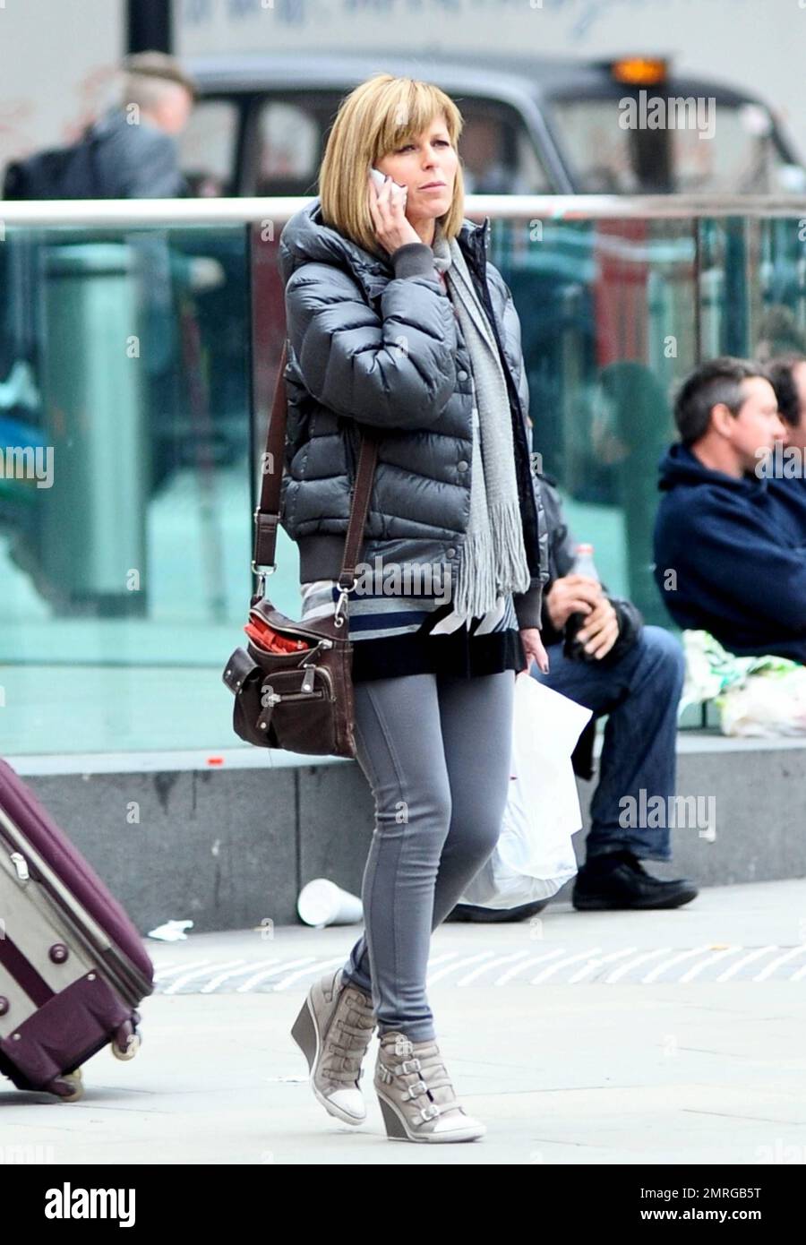 Packages in hand, GMTV presenter Kate Garraway chats on her cellphone ...