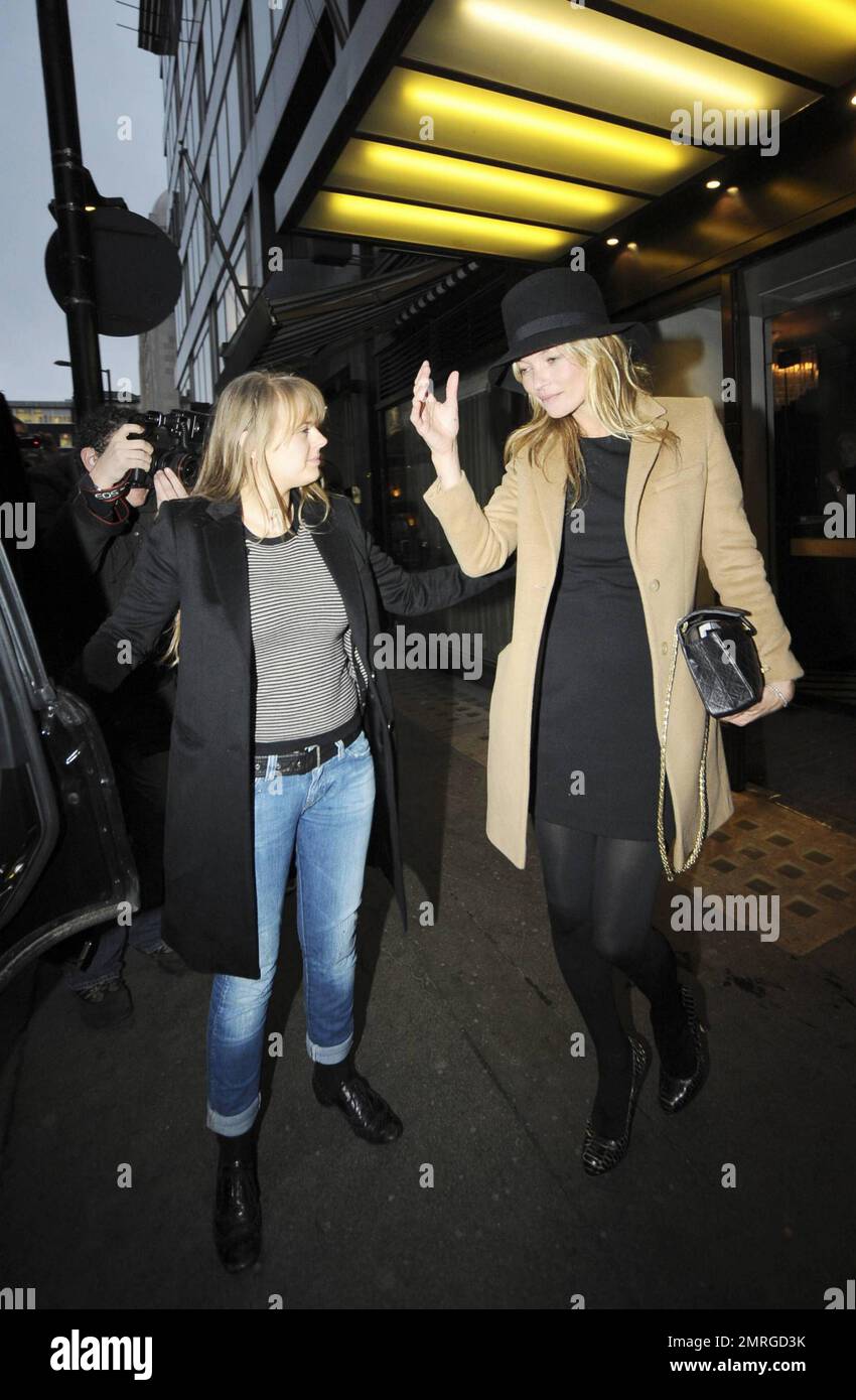Top model Kate Moss elegantly keeps her hand on her black fedora as she ...