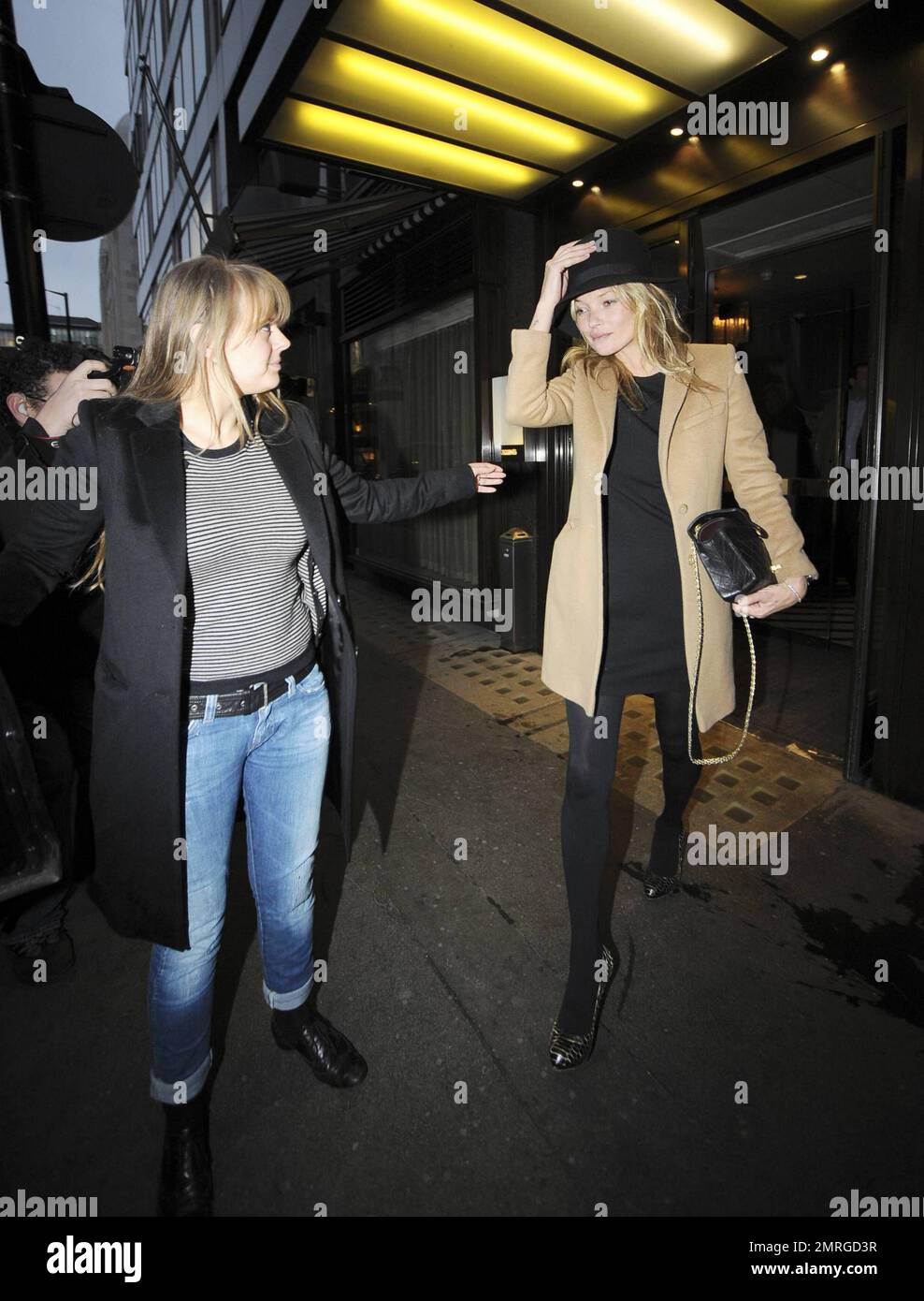 Top model Kate Moss elegantly keeps her hand on her black fedora as she ...