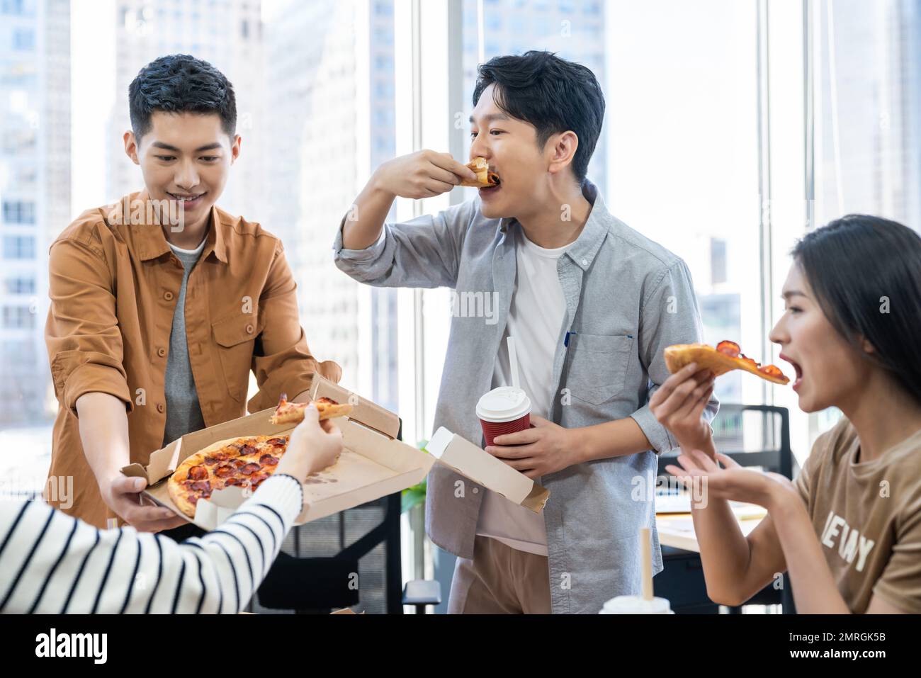 Young business people in the office to work overtime to eat fast food ...