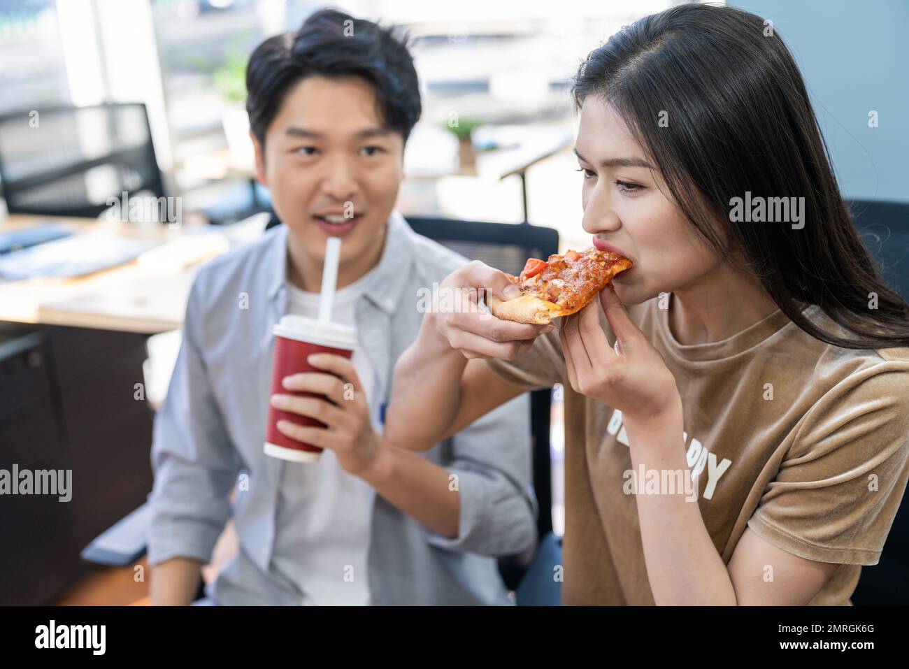 Young business people in the office to work overtime to eat fast food ...