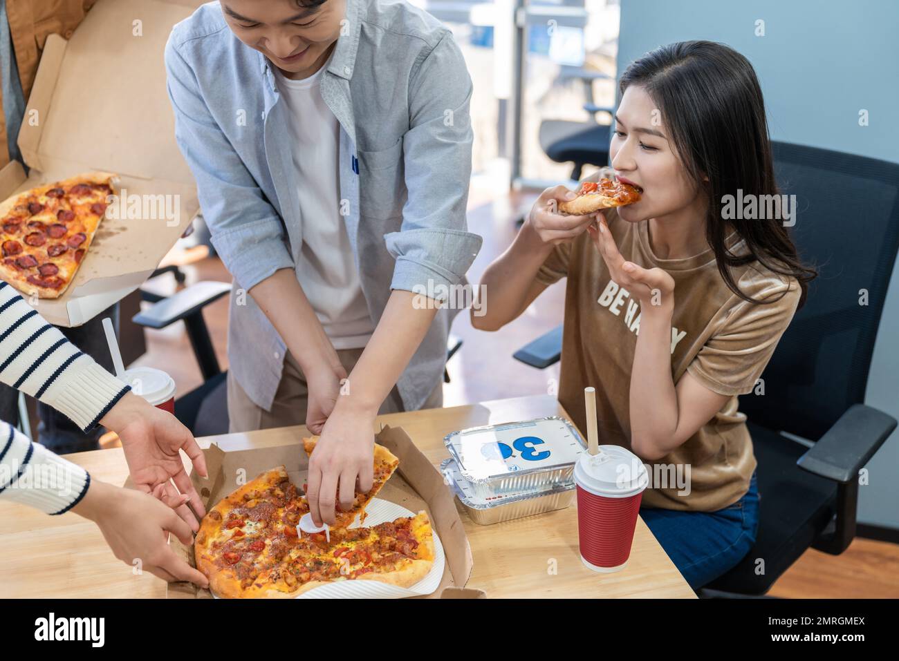 Young business people in the office to work overtime to eat fast food ...