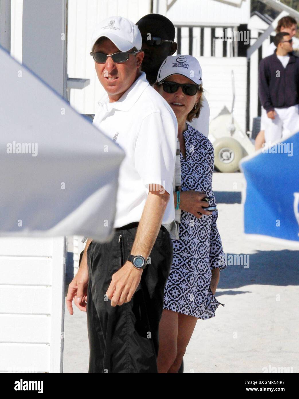 CBS news anchor Katie Couric covers up with a patterned top and hat ...