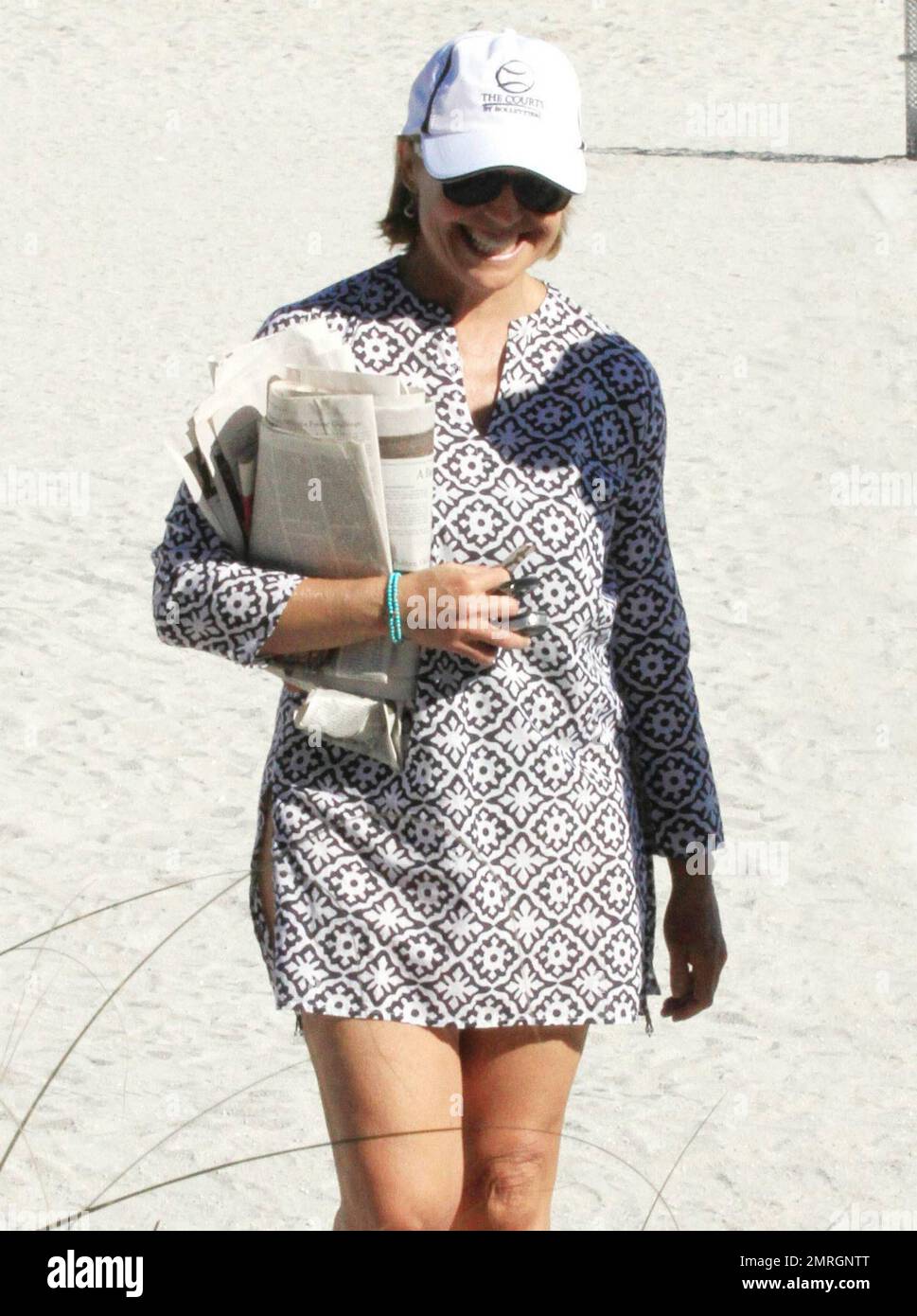 CBS news anchor Katie Couric covers up with a patterned top and hat ...
