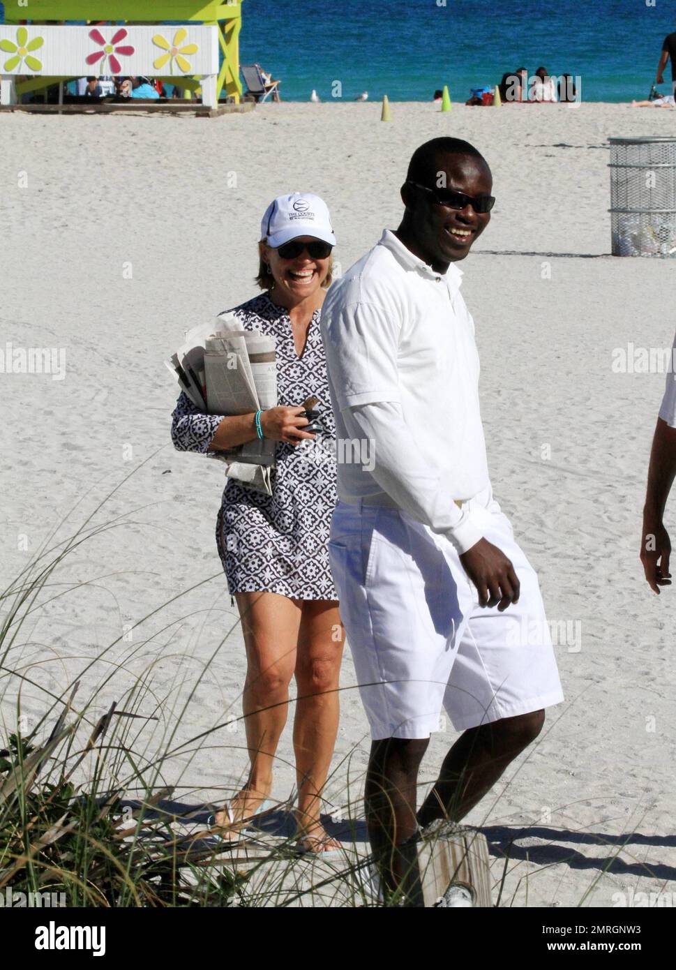 CBS news anchor Katie Couric covers up with a patterned top and hat ...