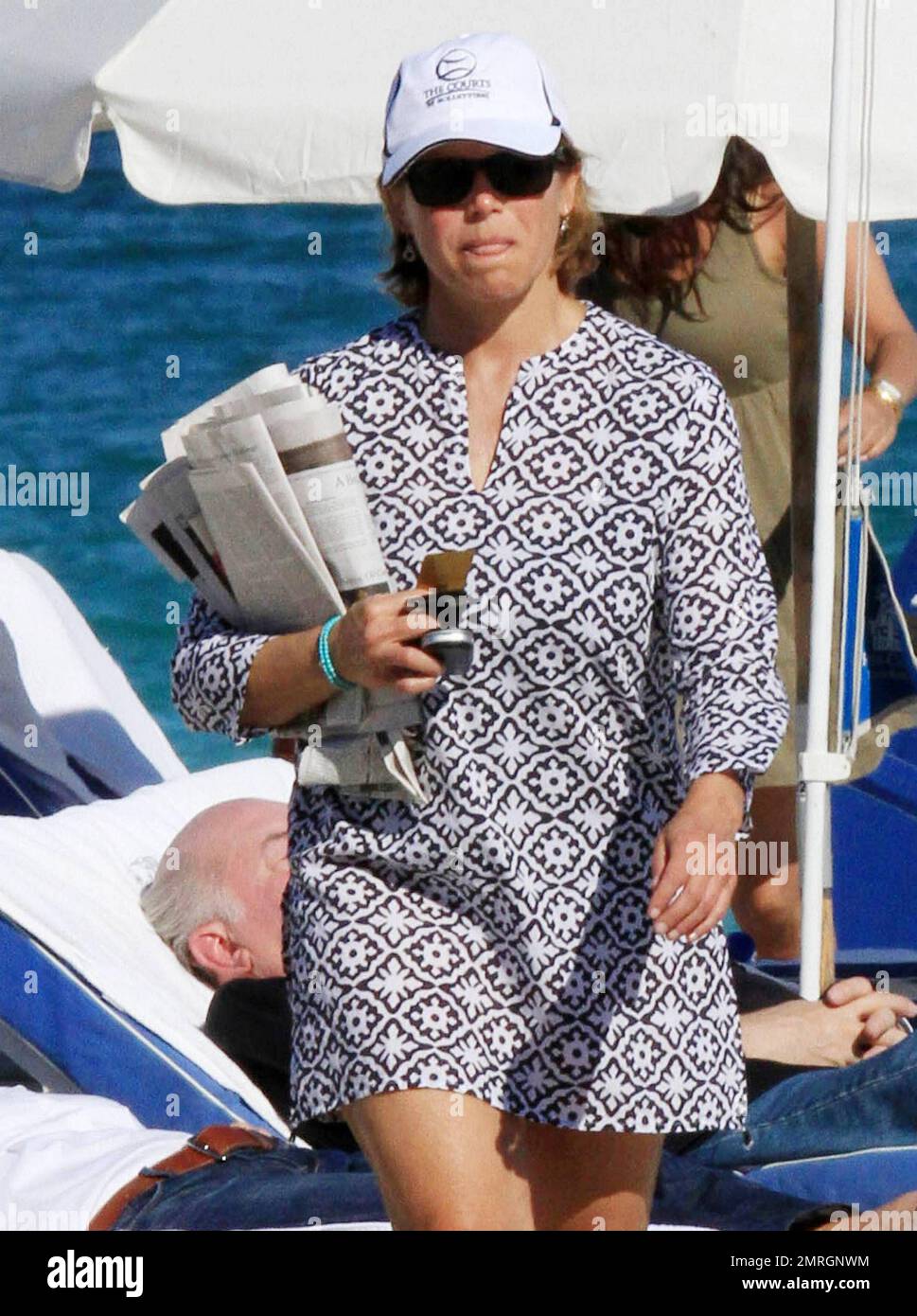 CBS news anchor Katie Couric covers up with a patterned top and hat ...