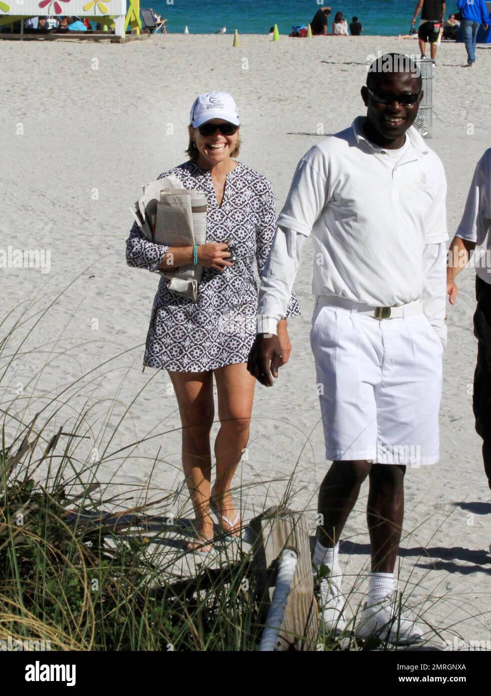 CBS news anchor Katie Couric covers up with a patterned top and hat ...