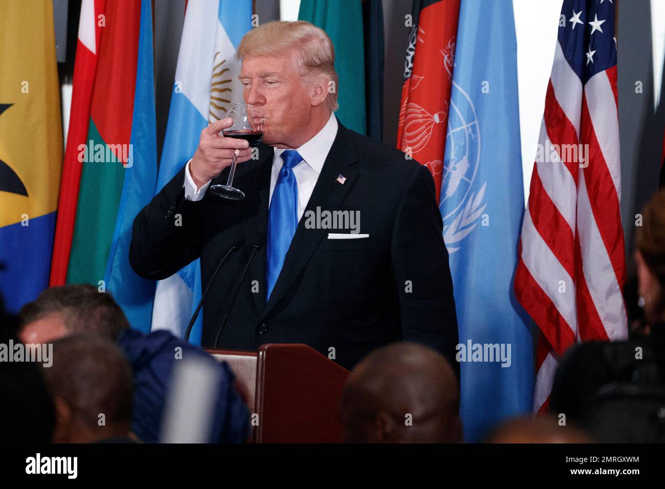 President Donald Trump sips from a glass after giving a toast during a ...