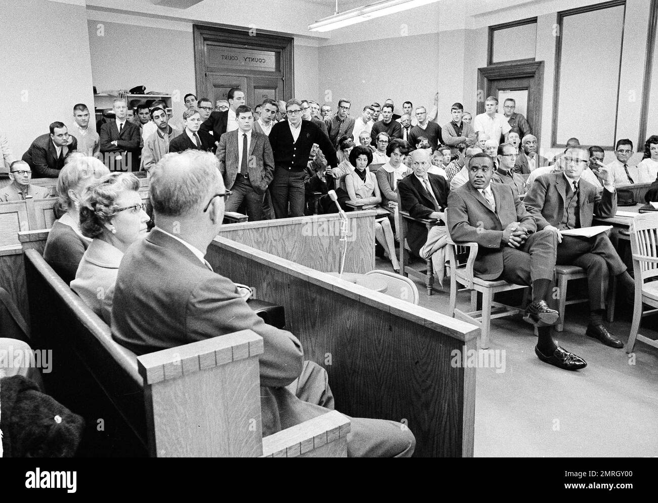 A standing-room-only crowd of interested spectators listen to the jury ...