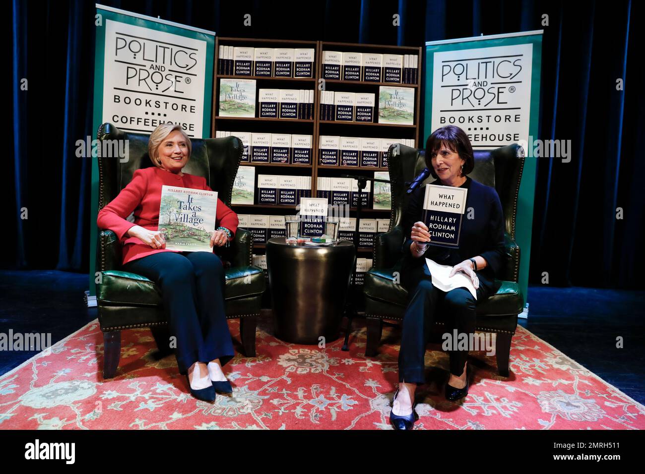 Hillary Clinton holds her book "It Takes A Village" as she sits on ...