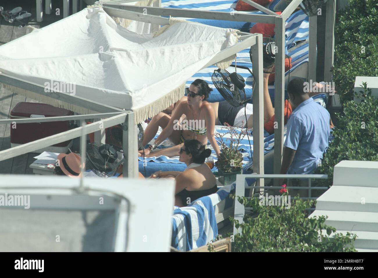 Katy Perry relaxes on a roof top pool in a tie dye bikini and sips on a ...