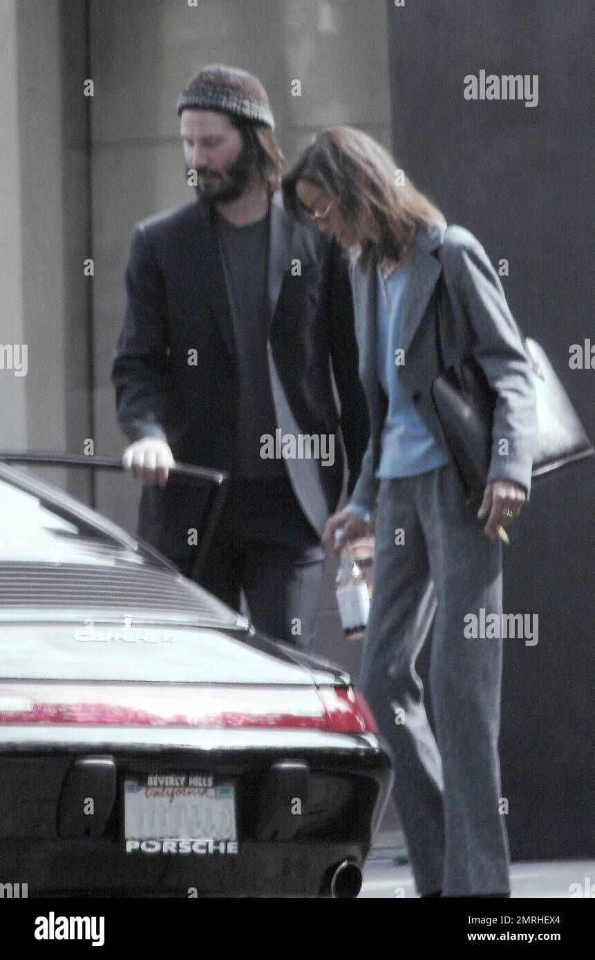 Exclusive!! A sad looking Keanu Reeves tenderly opens the car door for ...